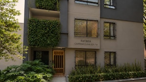Um edifício moderno com fachada plana, várias janelas e uma placa com o nome 'FATIMA'.