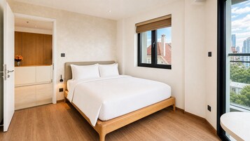 Um quarto com uma cama, uma janela com vista e uma porta que dá para um banheiro.