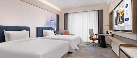Quarto de hotel com duas camas, uma escrivaninha, uma cadeira, uma televisão e uma janela grande com cortinas.