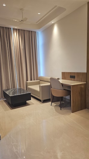 Uma sala de estar moderna com um sofá, uma escrivaninha e uma mesa de centro.