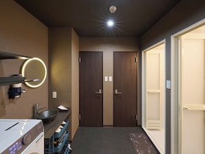 Uma casa de banho de hotel com uma pia, espelho e duas portas.