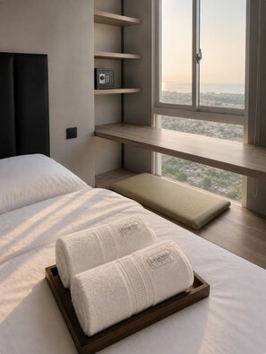 Quarto com duas camas, uma janela com vista e uma mesa de cabeceira com cofre.