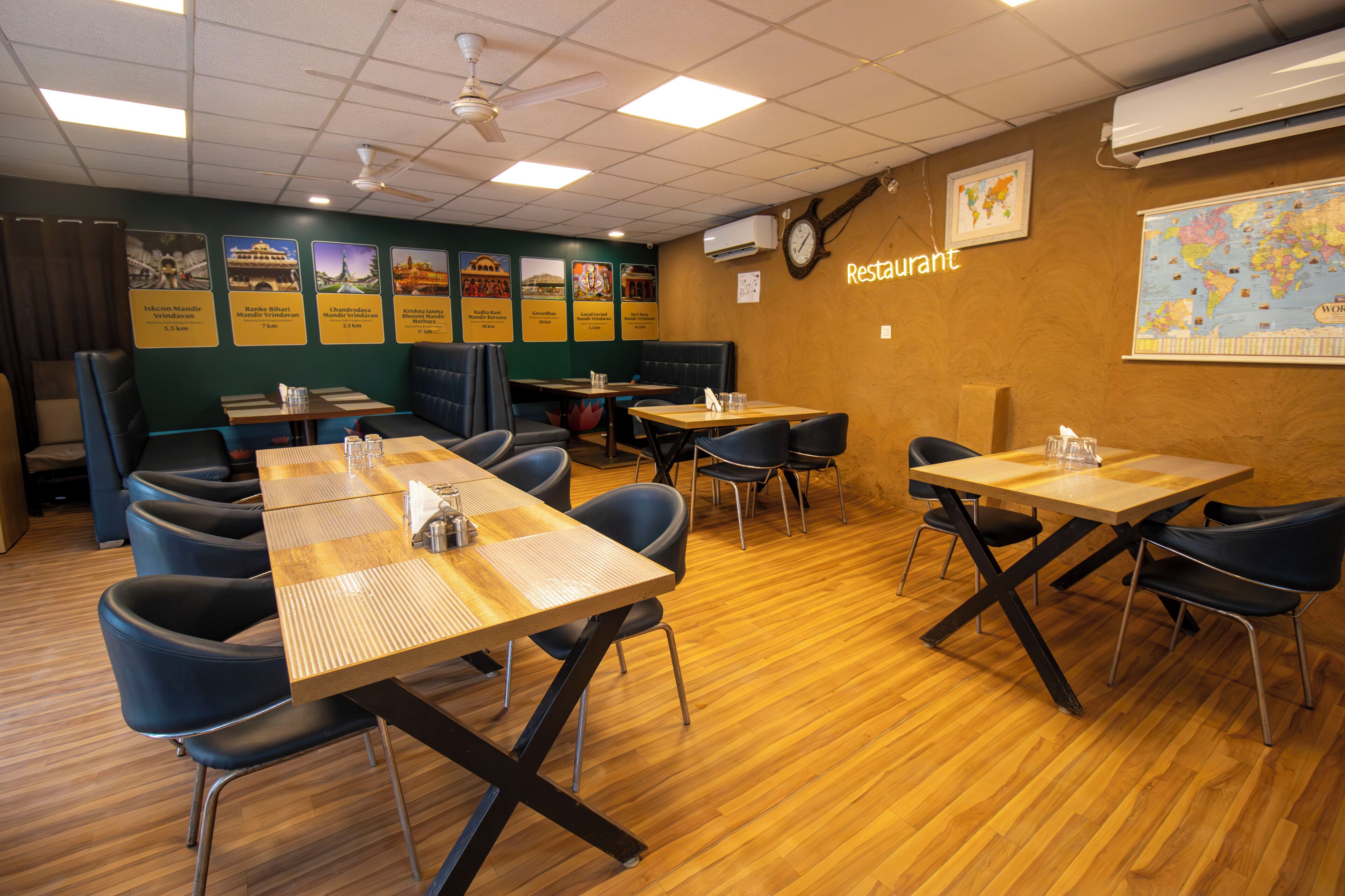 Um restaurante com cabines e mesas, um mapa-múndi na parede e um relógio.