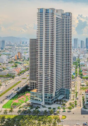 Um edifício alto com vários andares, rodeado por uma paisagem urbana.