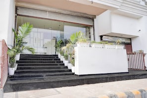 Entrada de um edifício com um conjunto de degraus que levam a uma receção.