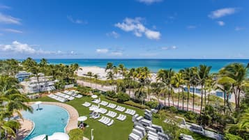 Um resort com piscina, espreguiçadeiras e vista para a praia e o oceano.