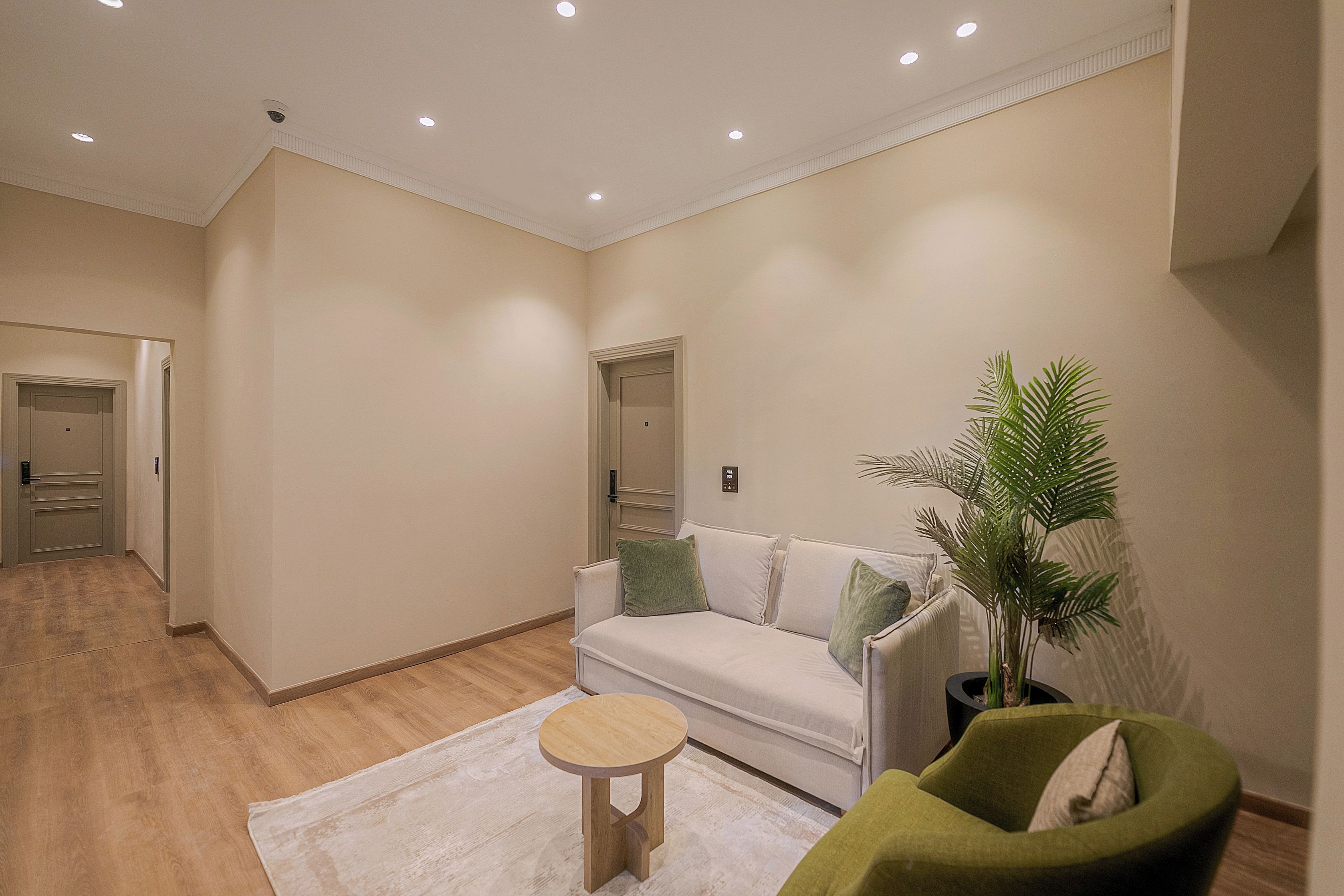 Uma sala de estar moderna com um sofá, uma mesinha redonda e um vaso de planta.