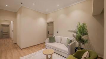 Uma sala de estar moderna com um sofá, uma mesinha redonda e um vaso de planta.