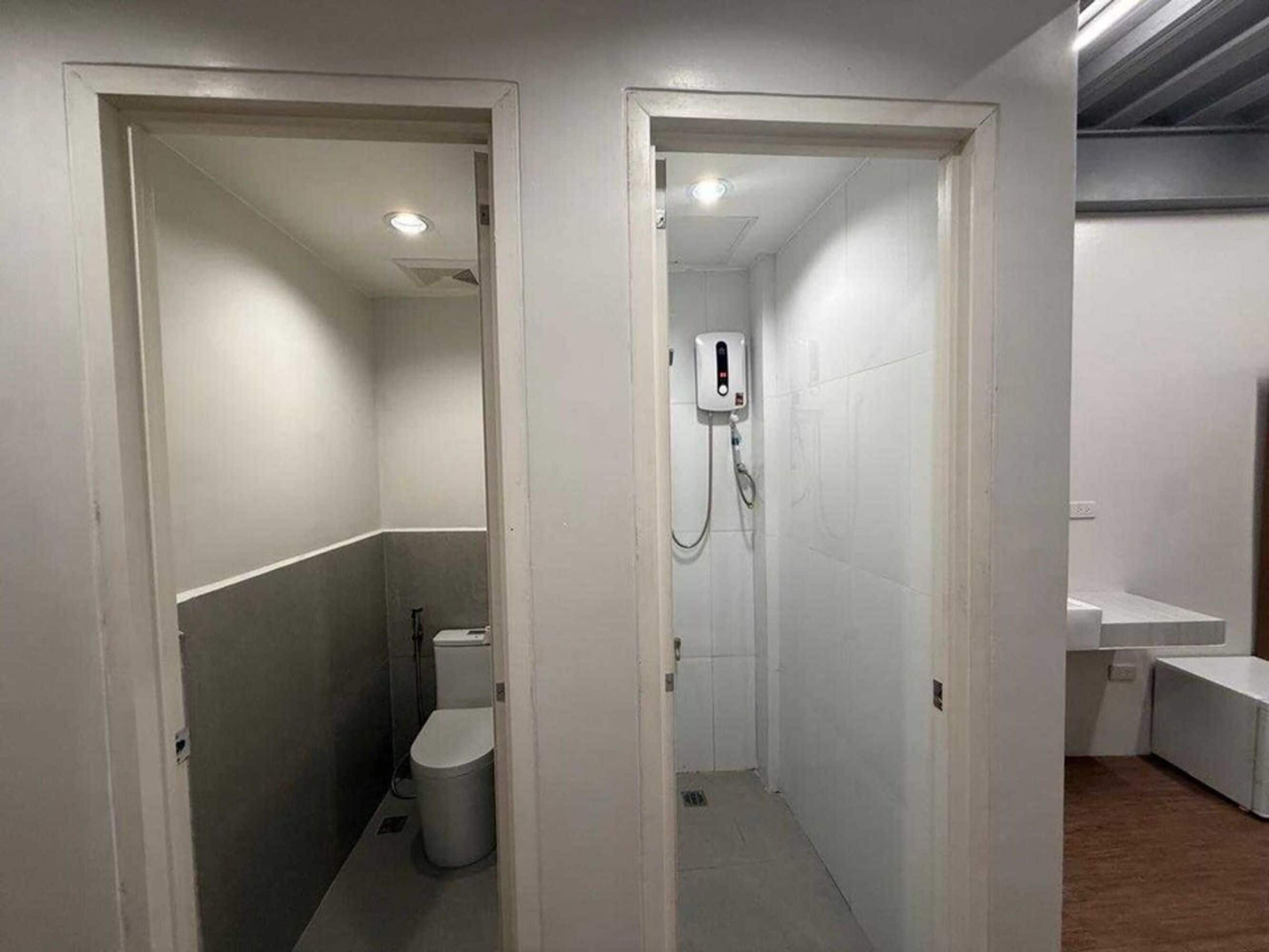 Casa de banho compacta com sanita, zona de duche e lavatório.