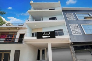 Um edifício com vários andares, varandas, uma placa indicando que é um serviço corporativo e uma porta de garagem.