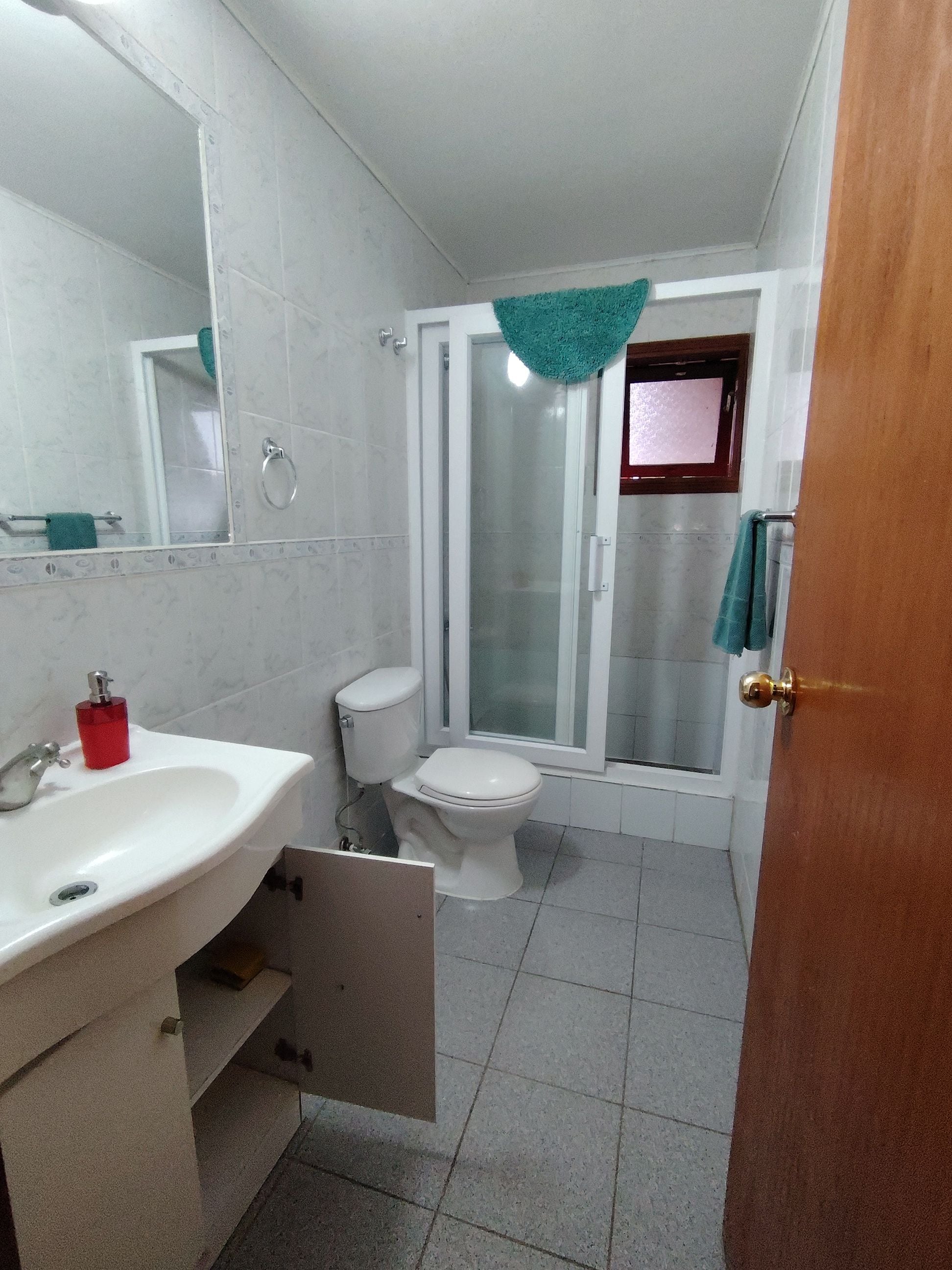 Casa de banho com lavatório, sanita e zona de duche.
