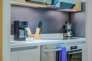 Uma cozinha moderna com cafeteira, liquidificador e porta-facas.