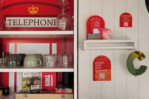 Um quarto com decoração inspirada em telefones, incluindo um emblema de coroa e um vaso de vidro.