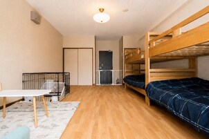 Quarto com uma cama de solteiro, uma escrivaninha e uma cadeira.
