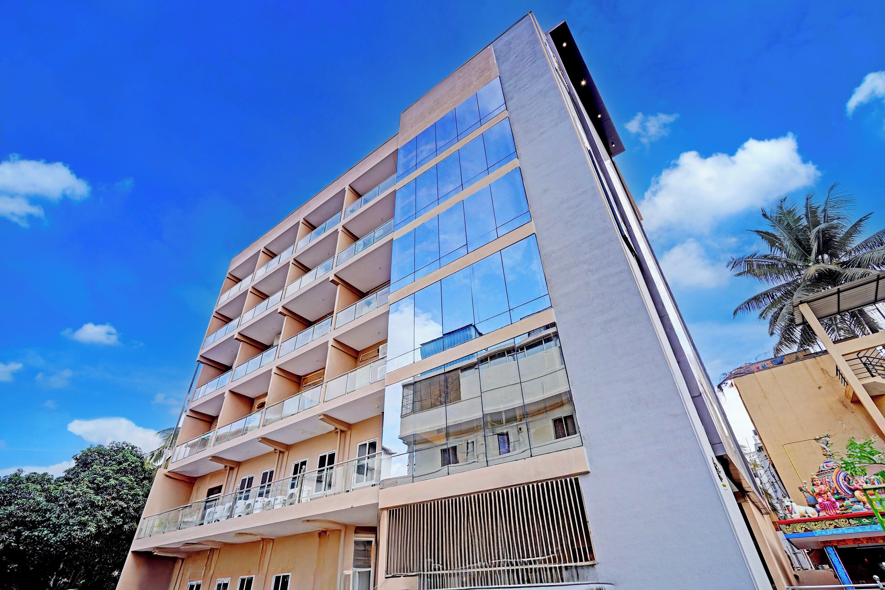 Um edifício de vários andares com design arquitetônico moderno, com varandas e grandes janelas.