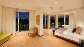 Quarto com cama, uma cadeira e vista para o exterior.