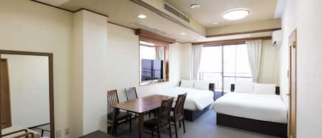 Quarto de hotel com uma cama, uma escrivaninha e cadeiras.
