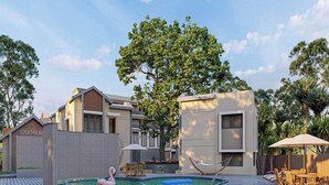 Piscina com espreguiçadeiras e uma rede, cercada por edifícios e árvores.