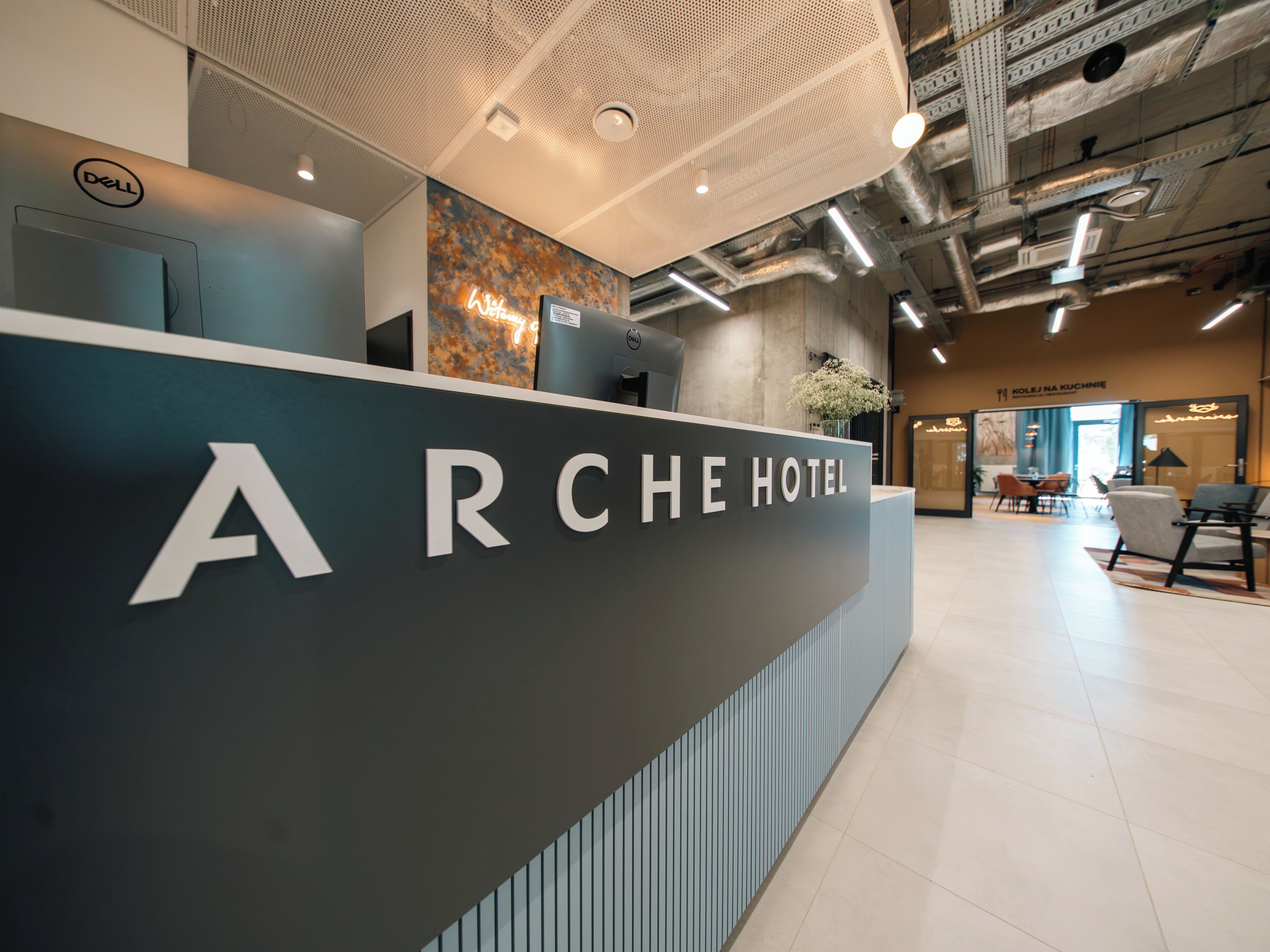 Uma receção com o nome 'ARCHE HOTEL' em destaque.