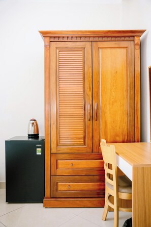 Um armário de madeira com duas portas e uma bancada com chaleira.
