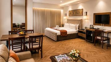 Quarto de hotel com cama, escrivaninha, mesa de jantar e televisão.