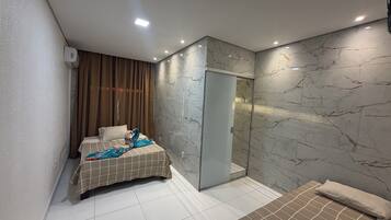 Quarto moderno com cama, closet espaçoso e banheiro.