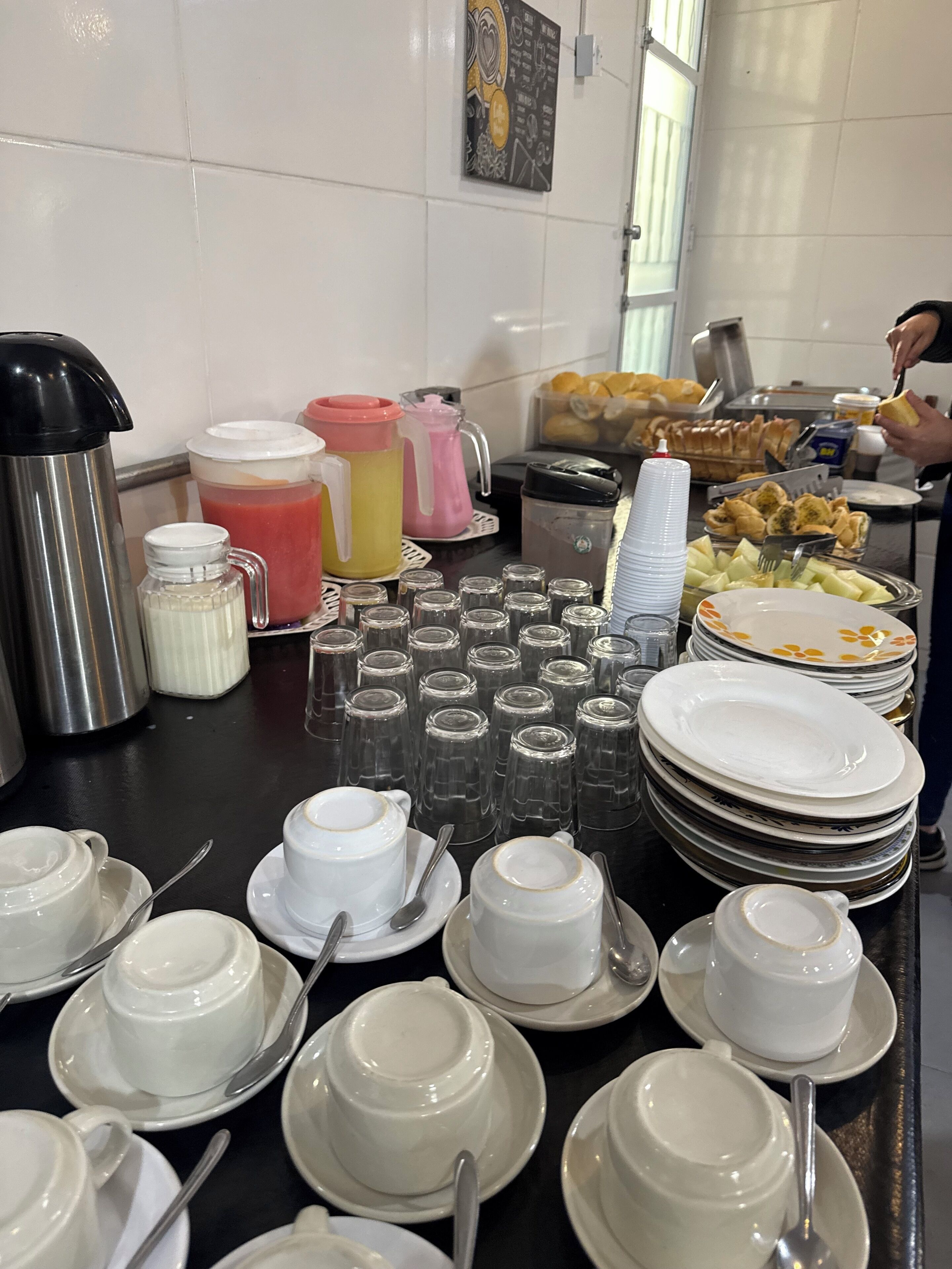 Uma mesa de buffet com diversos alimentos, bebidas e uma estação de café.