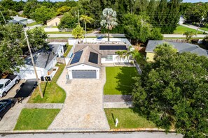 Um imóvel residencial com garagem, painéis solares e um gramado bem cuidado.