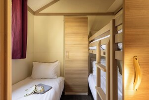 Quarto compacto com uma cama simples, um guarda-roupa de madeira e uma beliche.
