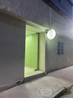 Entrada de um hotel com uma porta verde e uma placa indicando 'La Grande Maison Hotel & Bistro'.