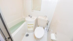 Um banheiro pequeno e branco com vaso sanitário, pia e banheira.