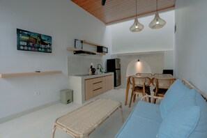 Espaço compacto com cozinha compacta, área de refeições e assentos.