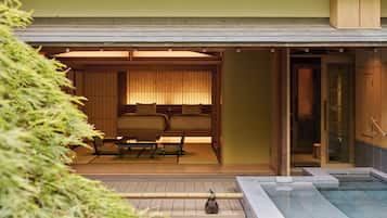 Um quarto japonês tradicional com tatames, uma mesa baixa e almofadas.