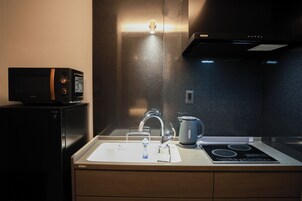 Uma cozinha moderna com micro-ondas, chaleira e fogão por indução.