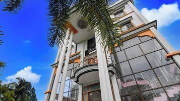 Um edifício de vários andares com varanda, janelas amplas e céu claro.