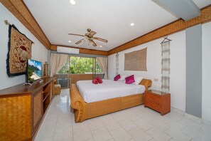 Quarto com cama grande, ventilador de teto, ar condicionado e televisão.