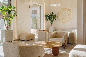 Uma sala de estar moderna com uma janela grande, uma mesa de centro redonda e um sofá.