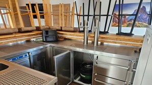 Uma cozinha compacta com máquina de lavar louça embutida, geladeira compacta e fogão a gás.