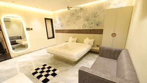 Quarto moderno com uma cama grande, um sofá, uma mesinha e um espelho.