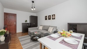 Uma sala de estar moderna com sofá, mesa de centro e área de jantar posta para refeição.