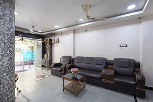 Uma sala de estar moderna com um sofá seccional, uma mesa de centro de madeira e um ventilador de teto.