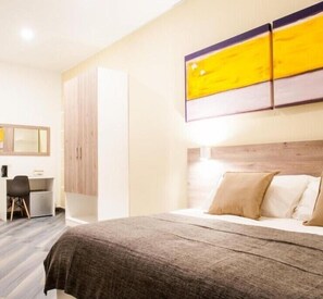 Quarto com cama, escrivaninha e guarda-roupa.