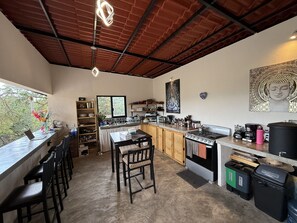 Cozinha moderna com bancada, mesa de jantar e cadeiras.