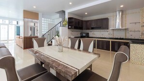Cozinha moderna com armários escuros, coifa de aço inoxidável e painel de azulejos com padrão.
