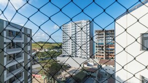Uma cerca de arame com edifícios ao fundo.