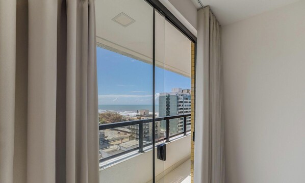 Uma varanda com vista para a praia e edifícios.