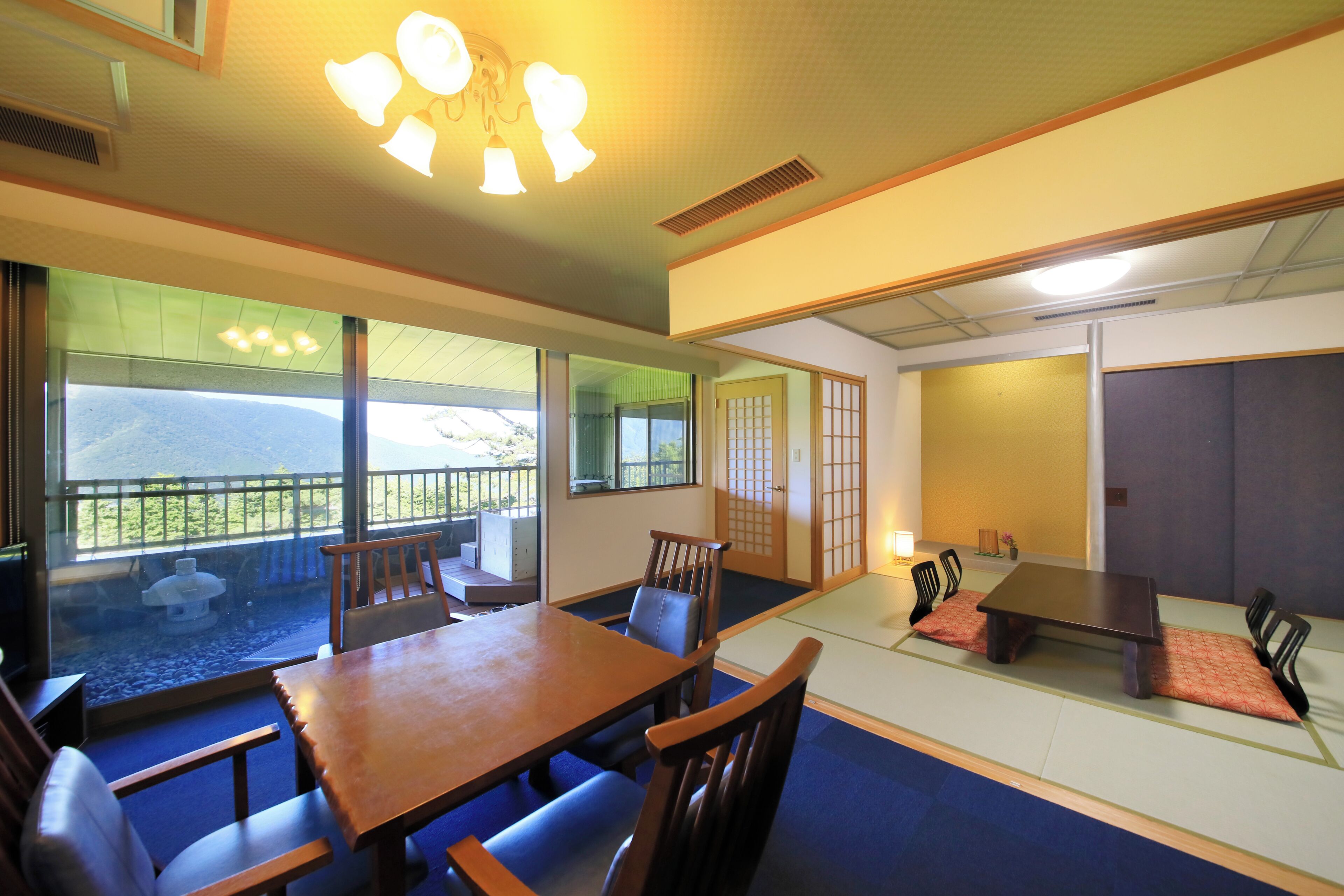 Um quarto em estilo japonês tradicional, com tatames, uma mesa baixa e mobiliário de madeira.