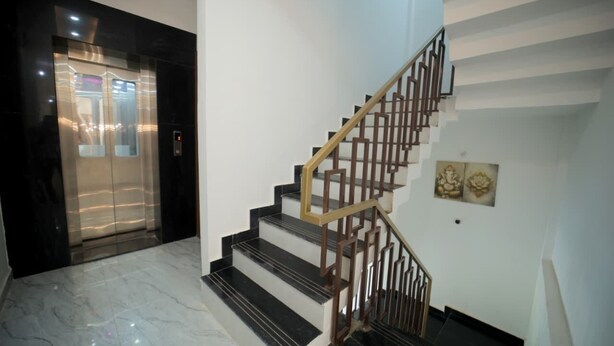 Um interior moderno com uma escadaria de mármore e um elevador.
