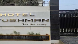 Placa de hotel com o nome 'HOTEL AYUSHMAN' e o slogan 'Entre no Luxo'.
