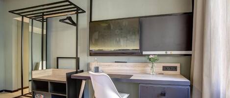 Um quarto moderno com uma cama, mesa de cabeceira e um espelho grande.